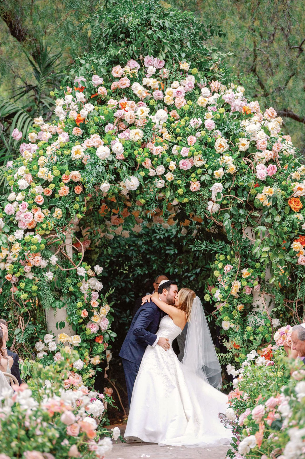 Bride & Groom Kiss Under Massive Floral Arch
