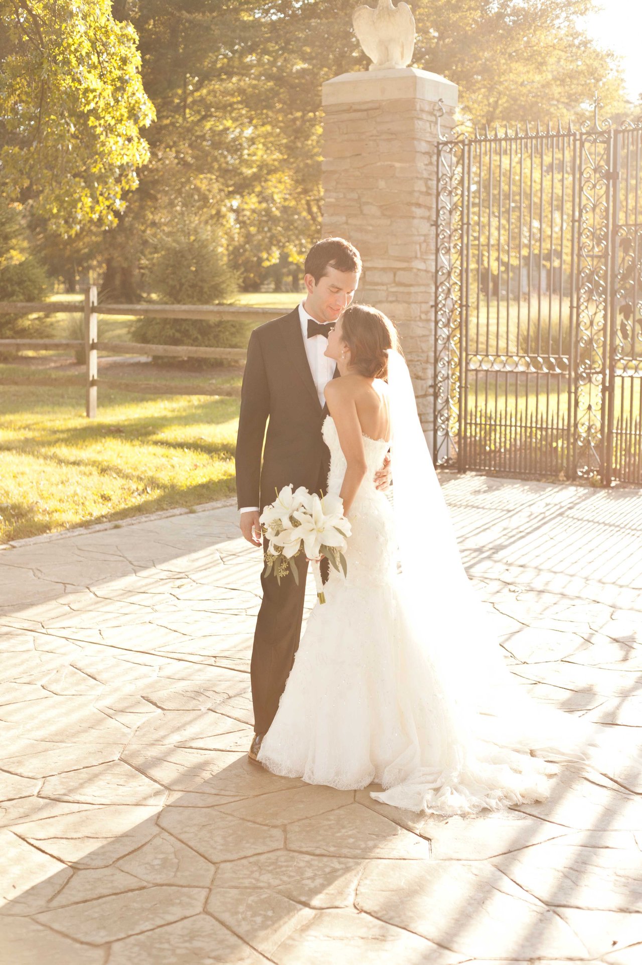 Bride and Groom Stand with White Flower Bouquet