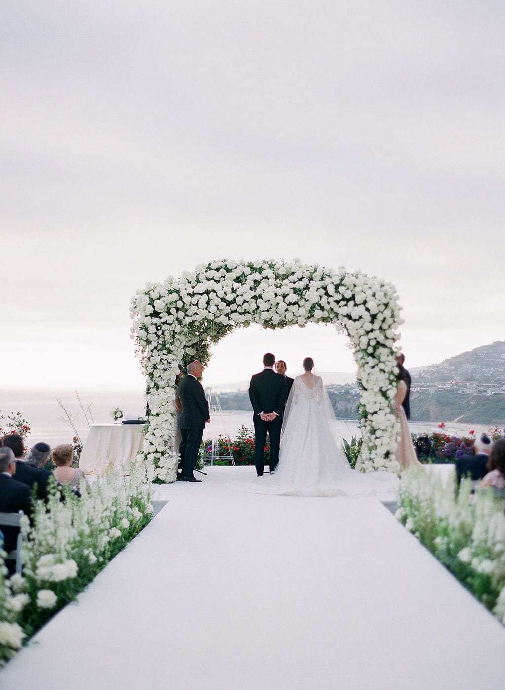 Bride & Groom Under White Floral Chuppah