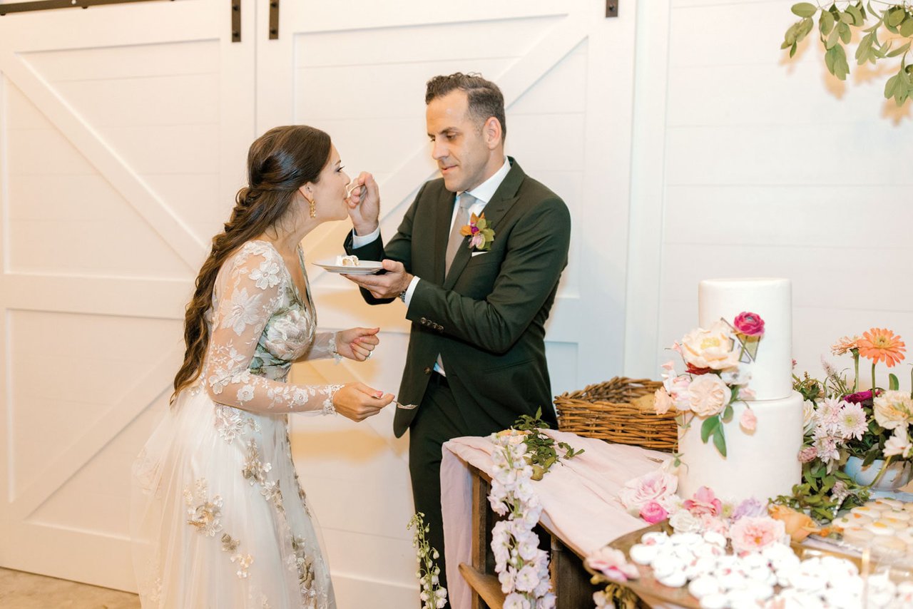 Groom Feeding Wedding Cake to Bride