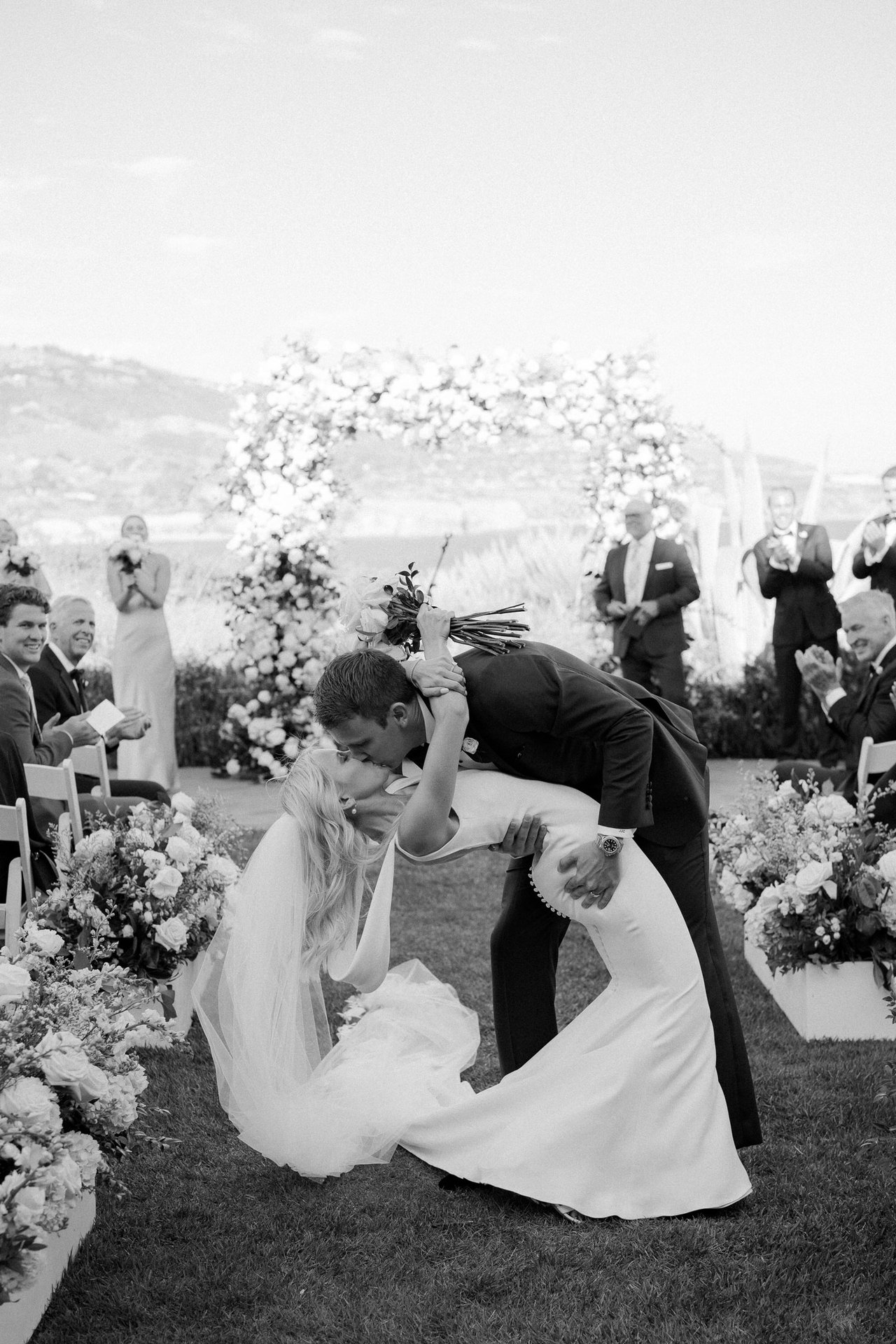 Groom Dipping Bride for Kiss After Ceremony