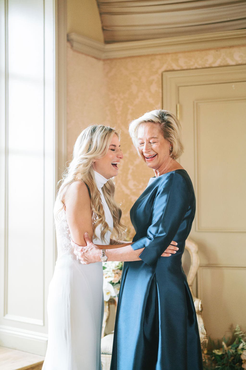 Bride Laughing with Mom in Bridal Suite