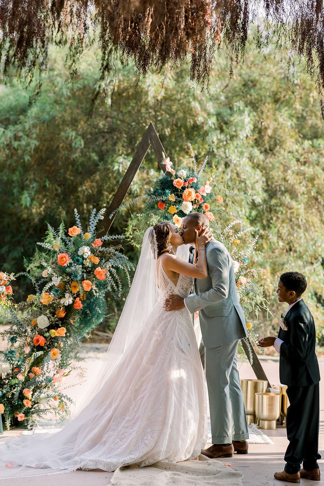 Newlywed Kiss In Front of Asymmetrical Arch