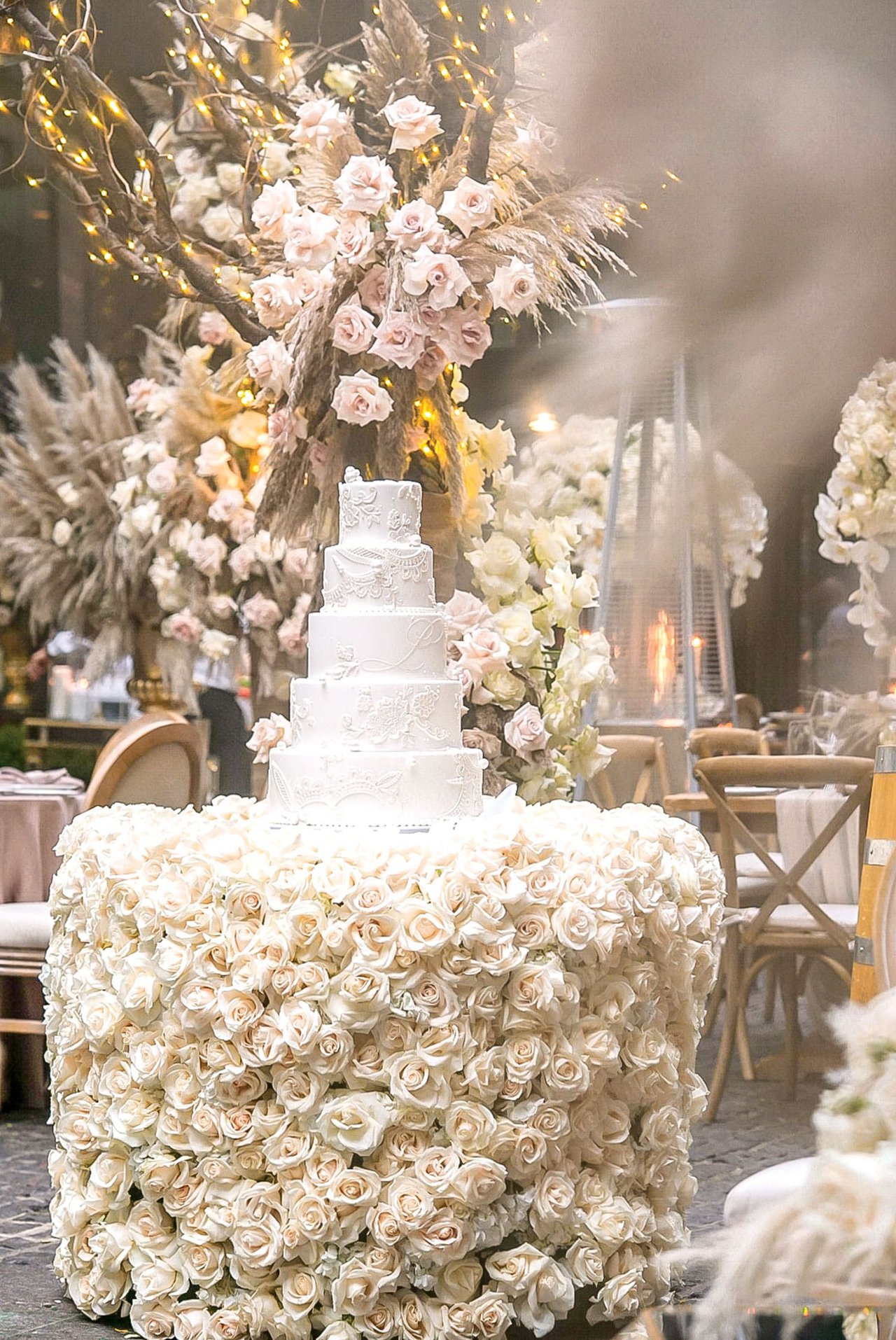 White Wedding Cake on Rose-Covered Table
