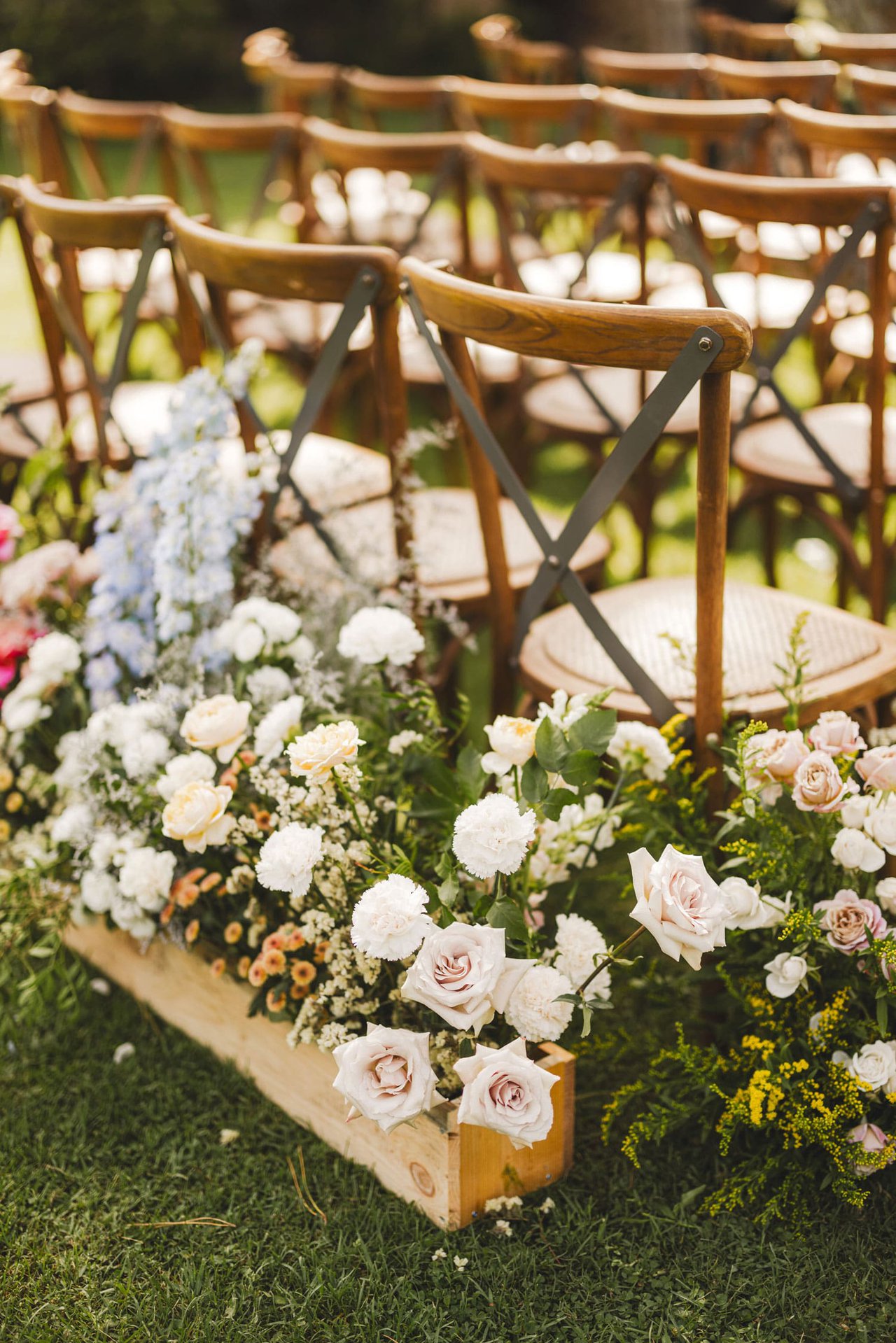 Flower Boxes Behind Wooden Ceremony Chairs