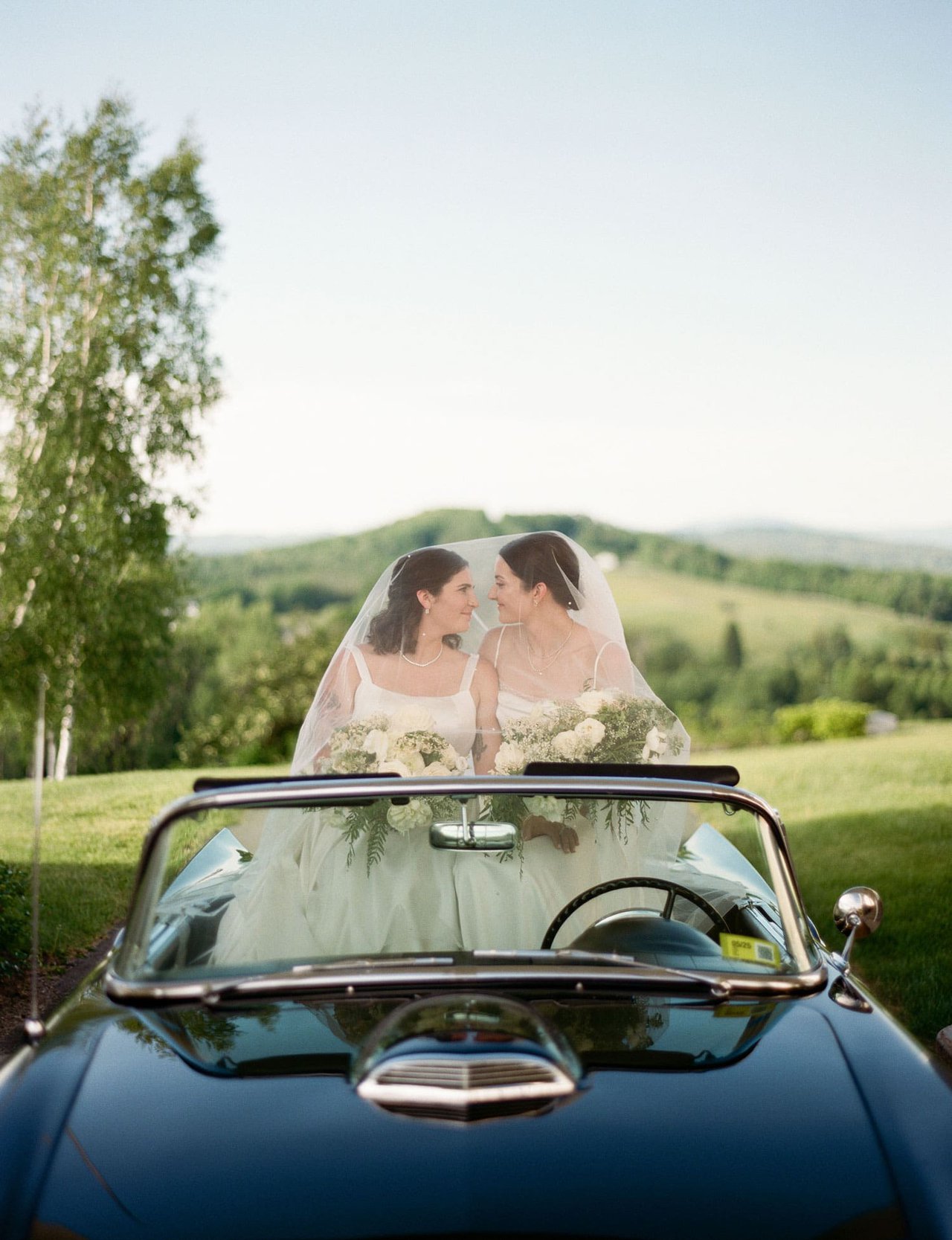 Two Brides on Back of Vintage Car