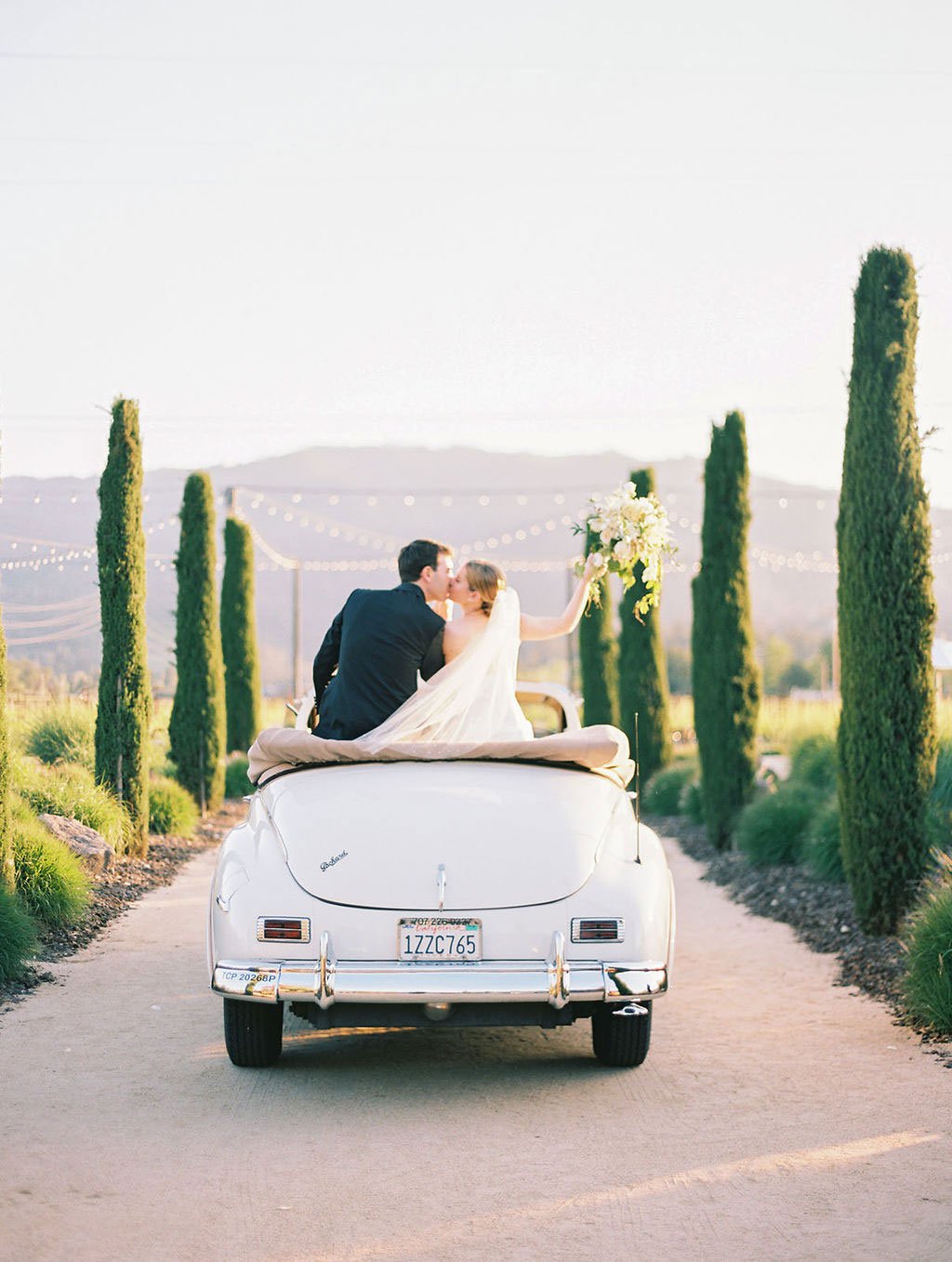 Bride & Groom on Back of Classic Convertible