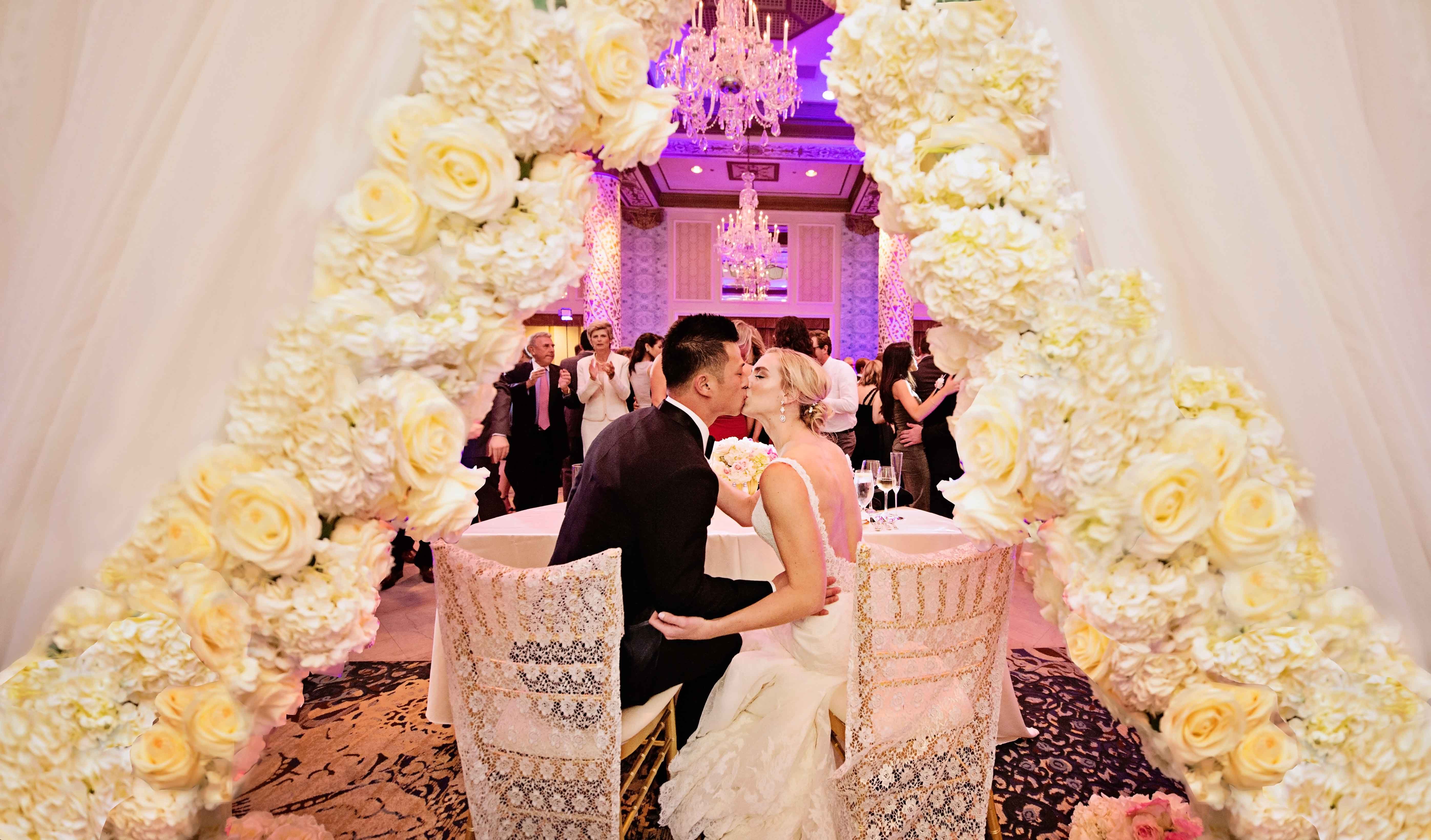 Bride and Groom Kiss at Sweetheart Table