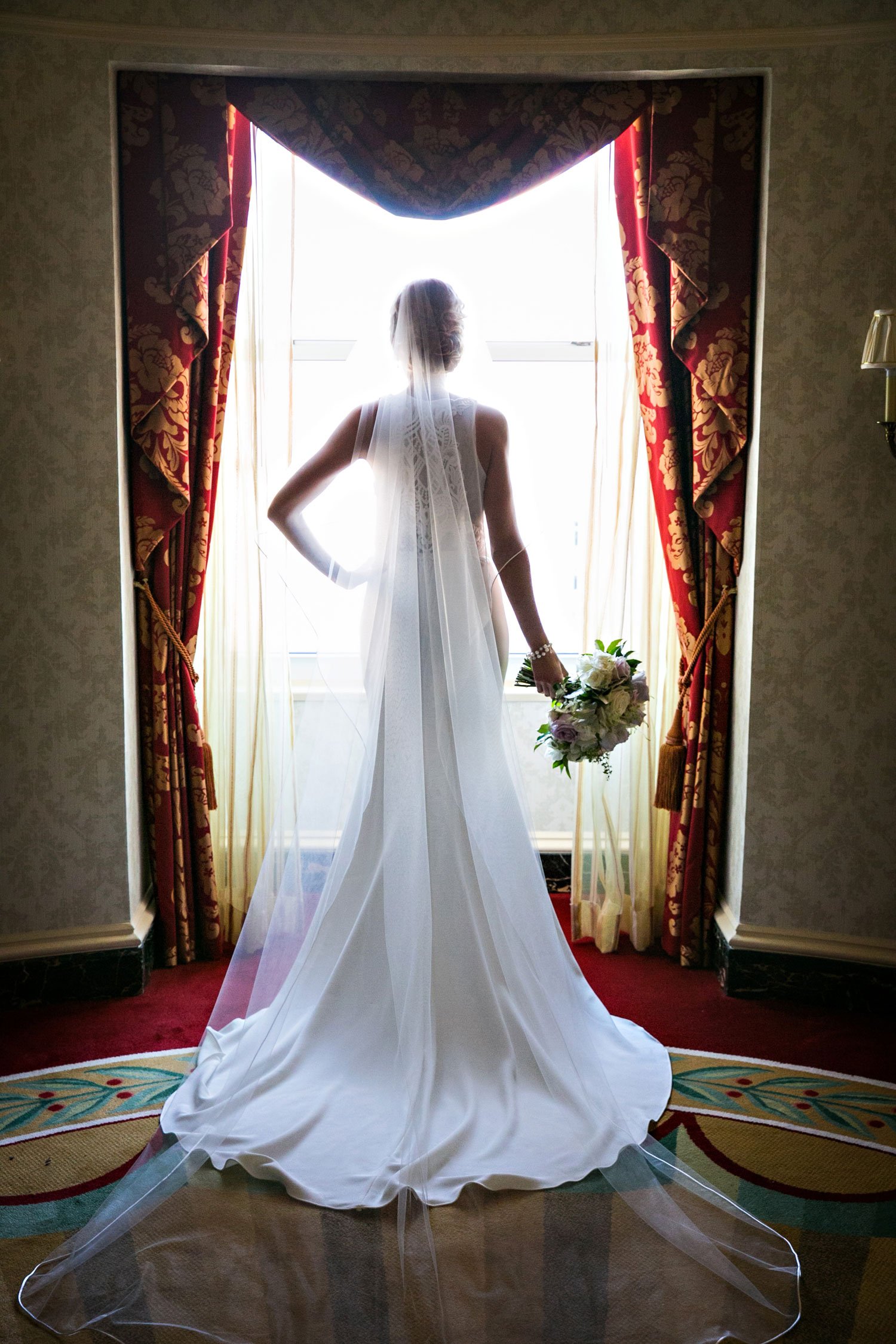 Bride in Form-Fitting Bridal Gown in Window