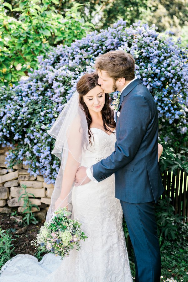 Groom Kissing Bride on Forehead in Garden