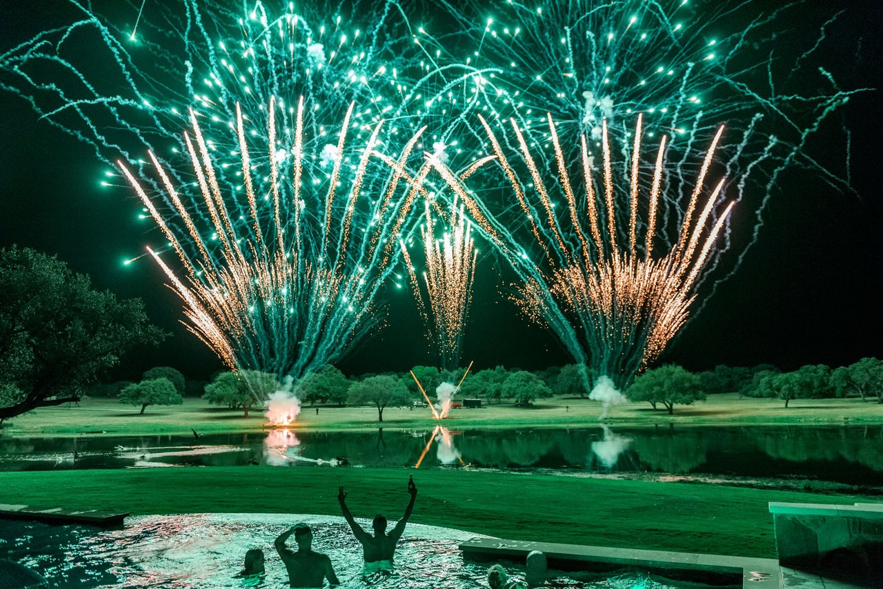 Guests Celebrating in Pool with Fireworks