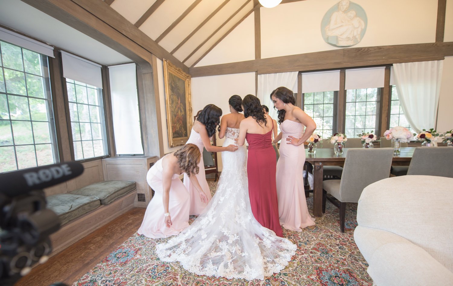 Bridesmaids Help Bride Into Dress