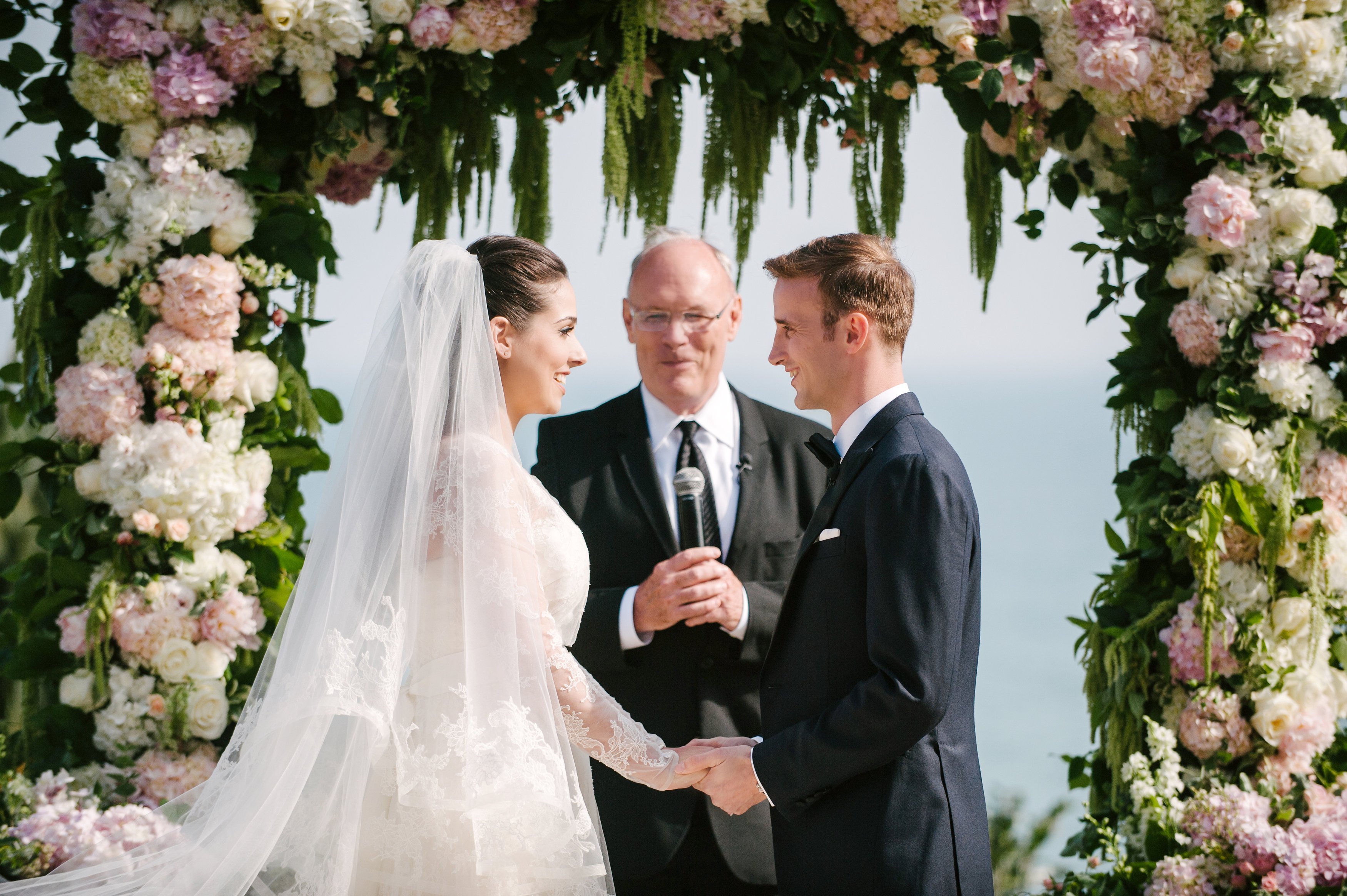 Bride and Groom Exchange Vows Under Arch