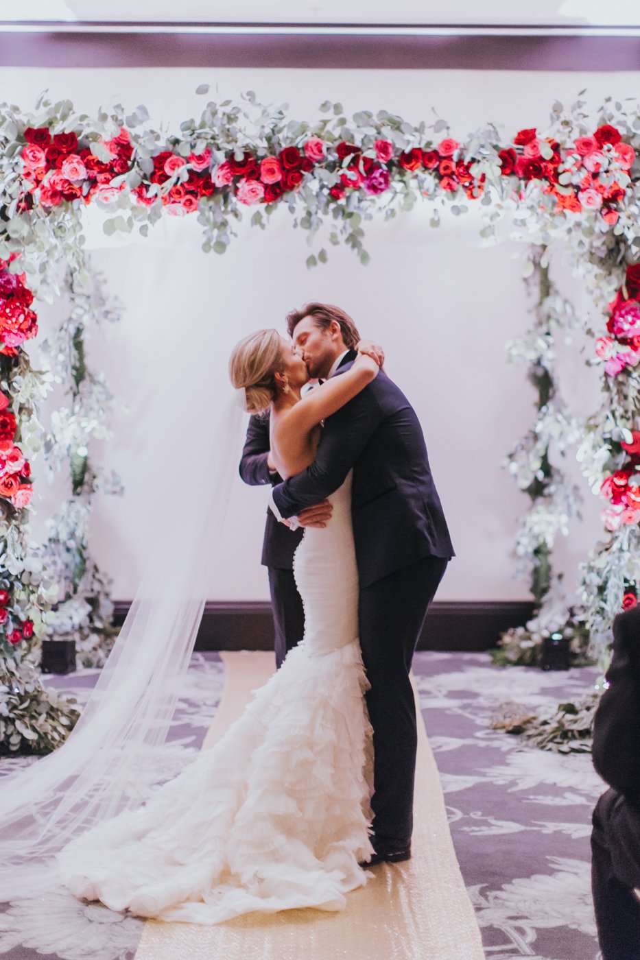 Bride and Groom Embrace During First Newlywed Kiss