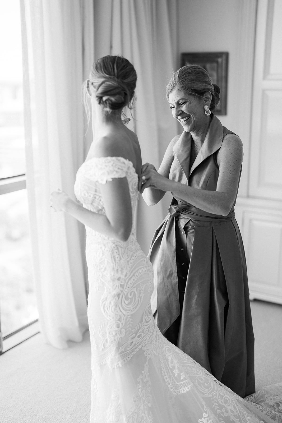 Mother Of Bride Helping Daughter With Gown