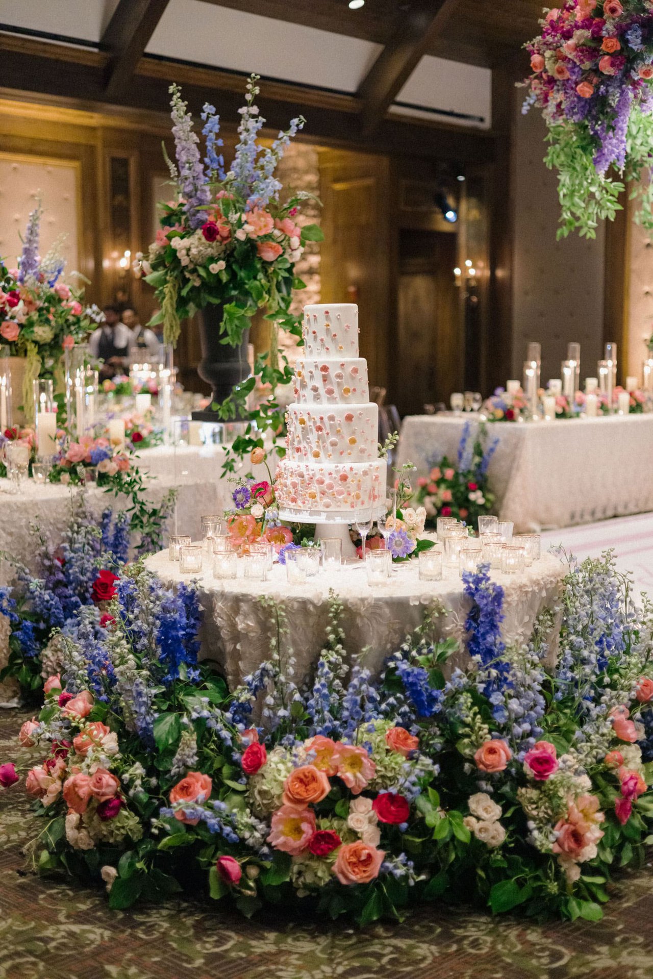 Floral Wedding Cake on Table with Flowers at Base
