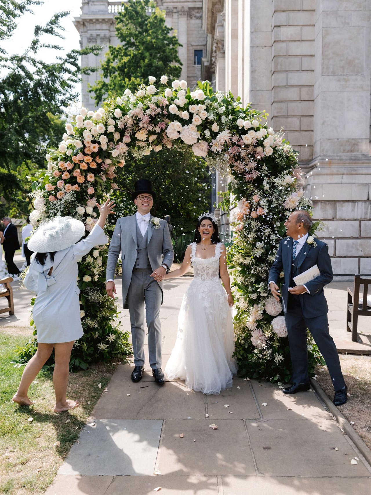 Newlyweds Walking Under Floral Arch