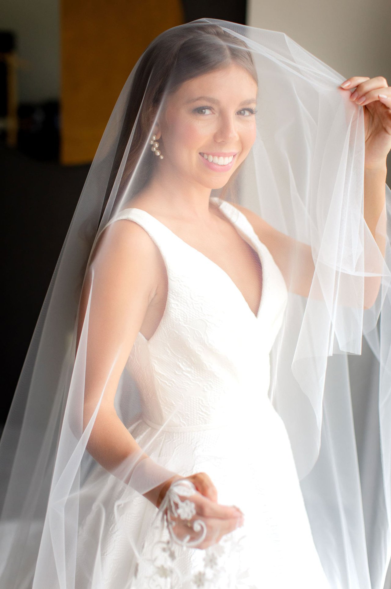 Bride Holding Veil Over Face