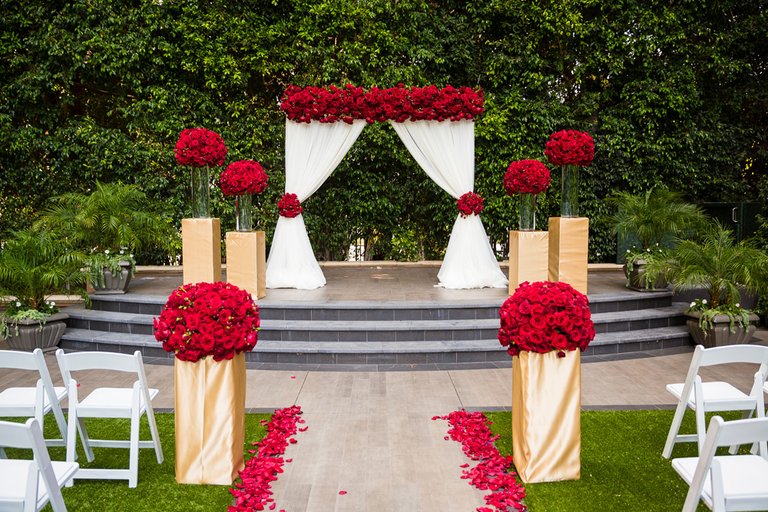 Outdoor Ceremony with Red Roses and Gold Pillars
