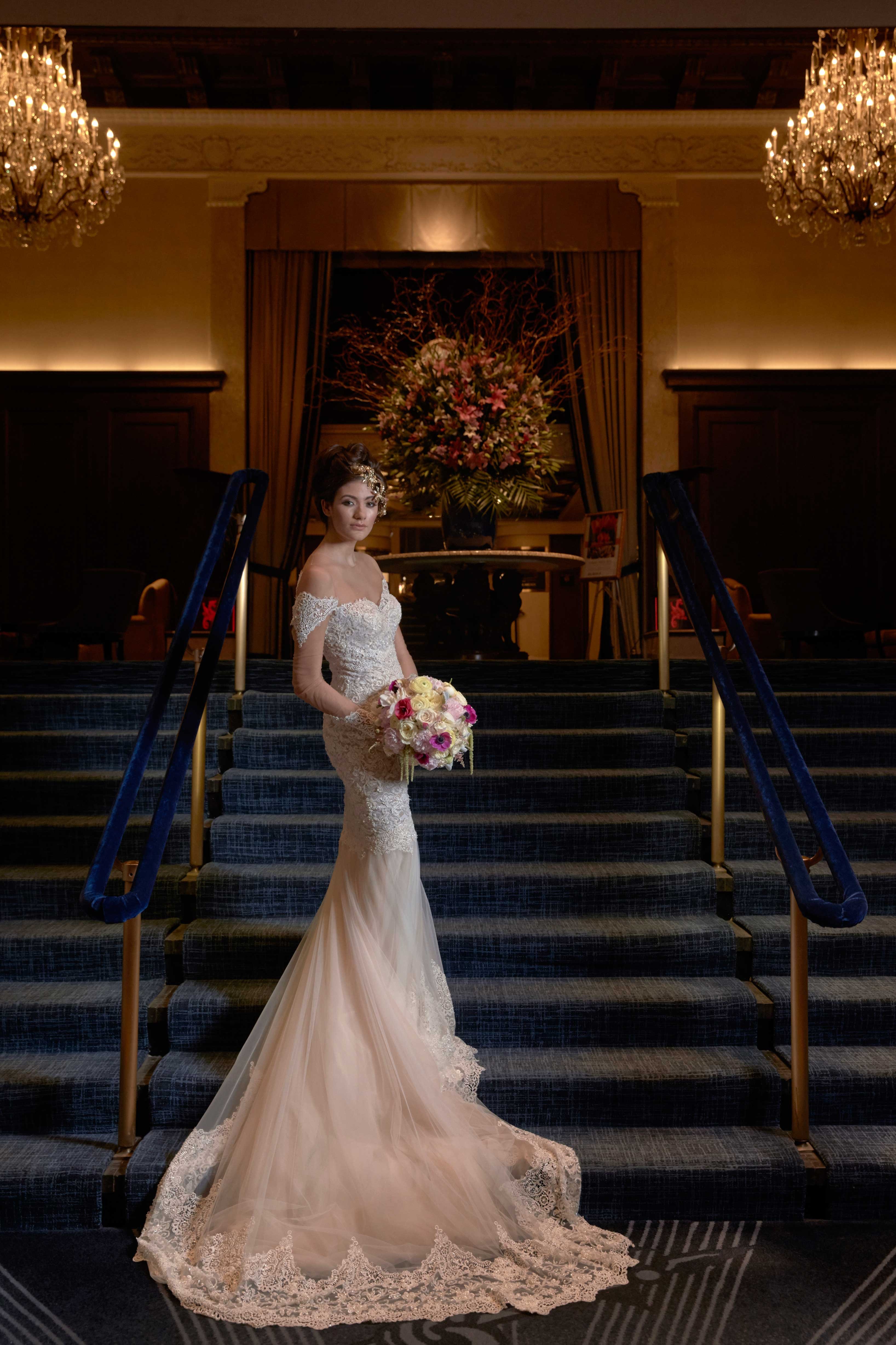 Bride in Lace Gown with Bouquet on Stairs