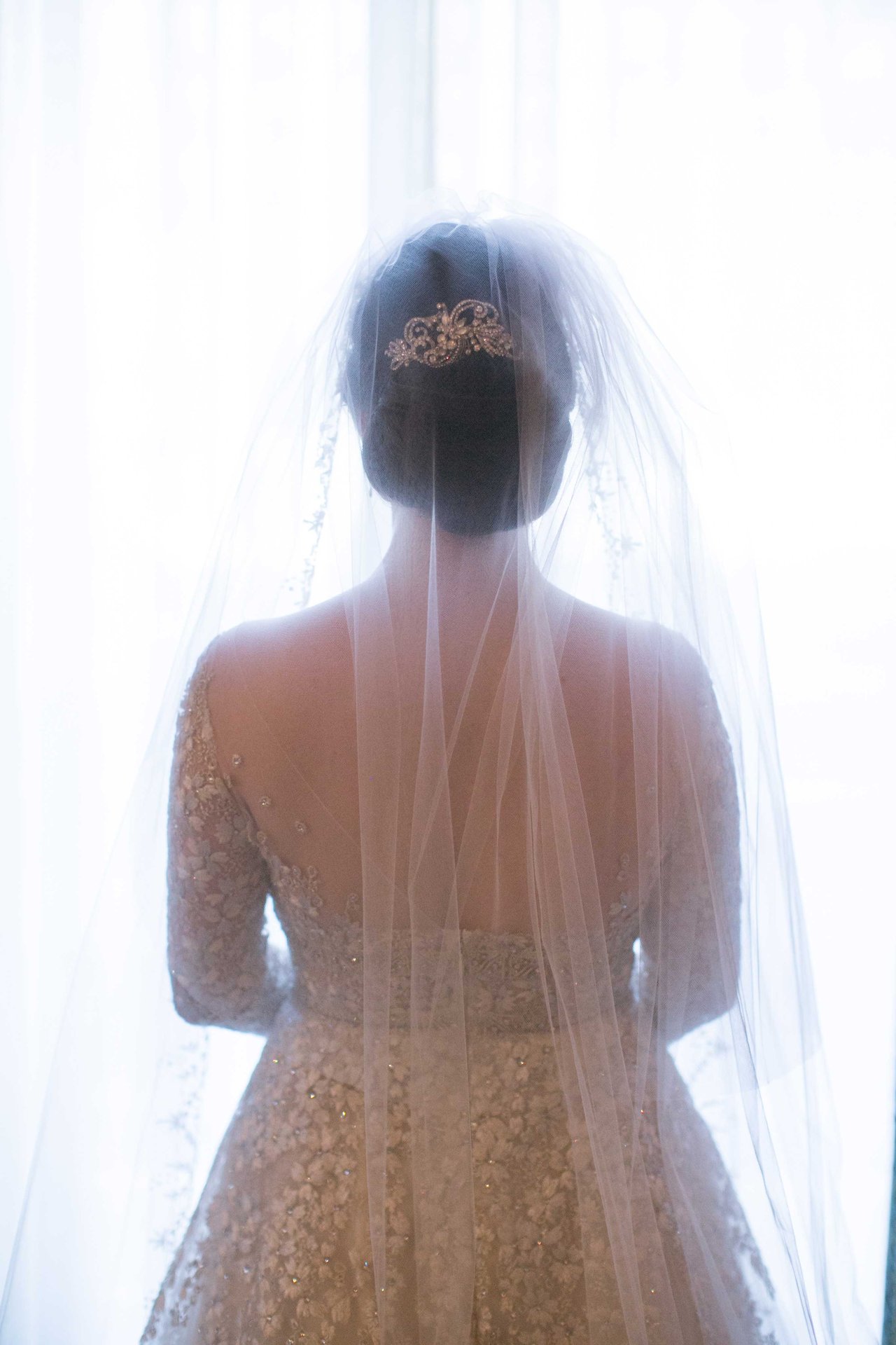Bride Showing Off Back of Dress, Veil, Headpiece
