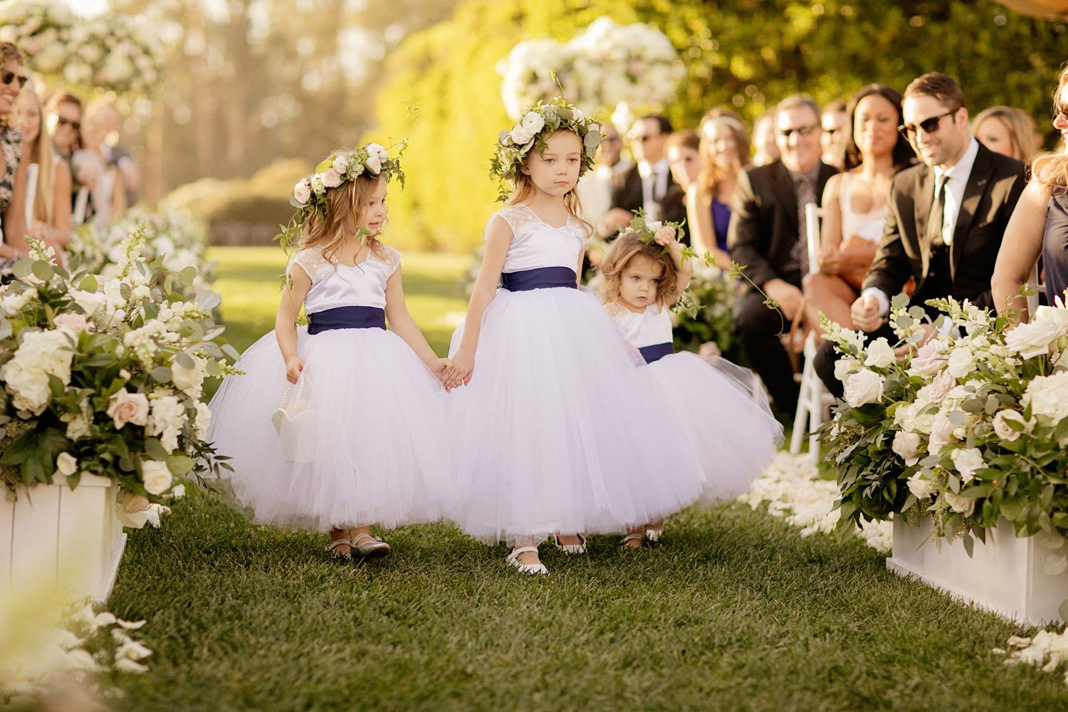 Flower Girls in Crowns Walking Down Aisle
