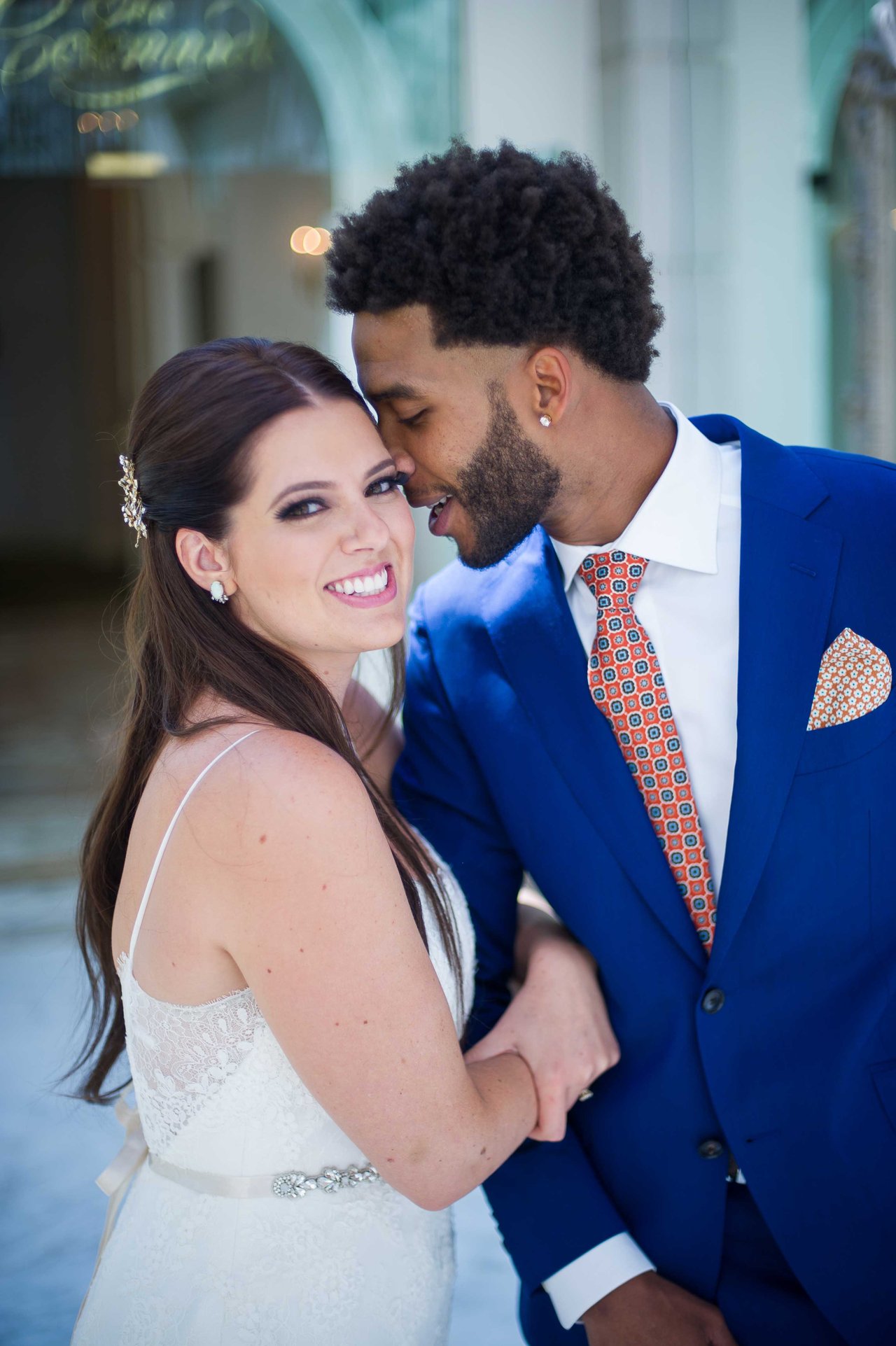 Groom in Blue Tuxedo Embraces Bride