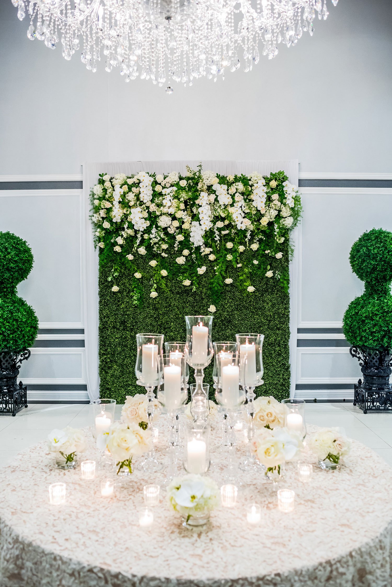 Table with Candles in Front of Hedge Wall