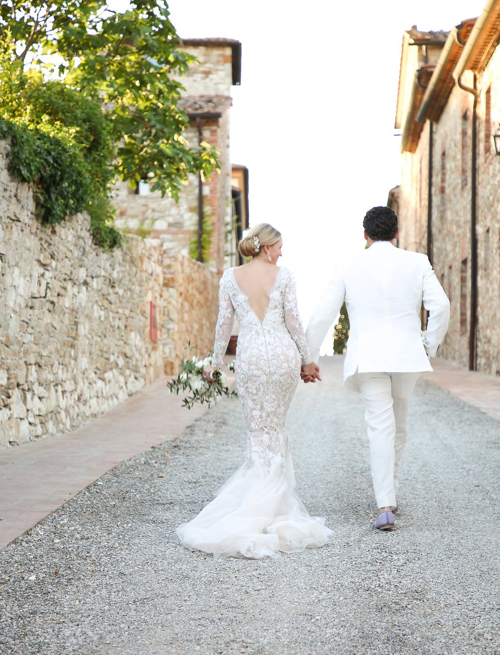 Bride in V-Back Dress Holding Hands with Groom